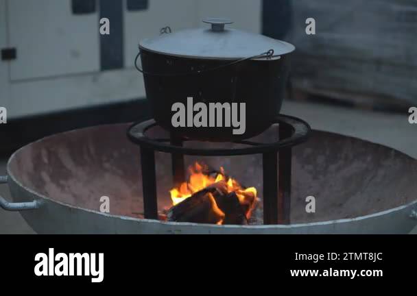 The process of cooking in a cauldron on a campfire in a forest area ...