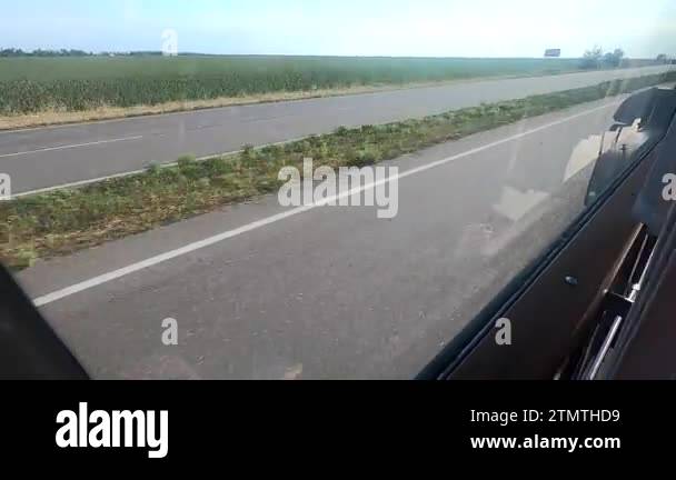 View from the bus window. View of the fields, trees, blue sky, the road ...