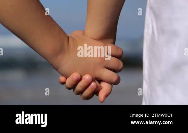 Close up of childrens tightly holding hands. Children hold hands on ...