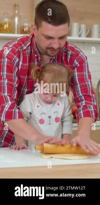 Vertical Screen: father and daughter having fun cooking together ...