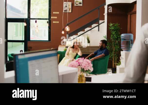 Hotel staff talking to guests in lobby, receptionist offering luxury ...