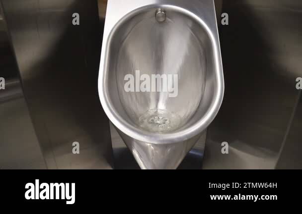 Sanitary metal urinal, toilet bowl in public bathroom with hygienic ...