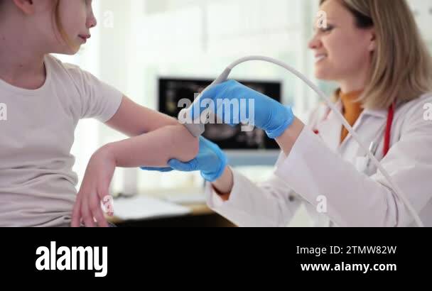 Traumatologist doctor conducts ultrasound examination of elbows of ...