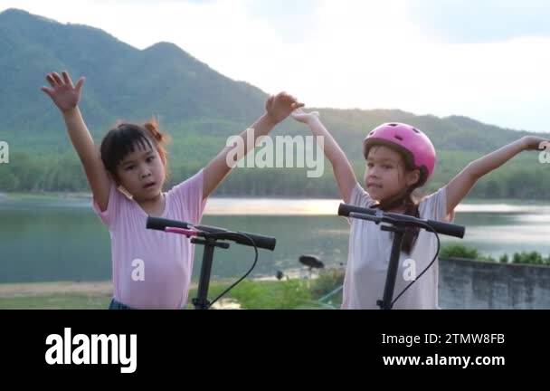 Two cute little girls smiling and posing together in summer garden ...