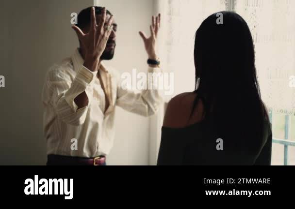 Angry man arguing with girlfriend by window at home. Male person ...