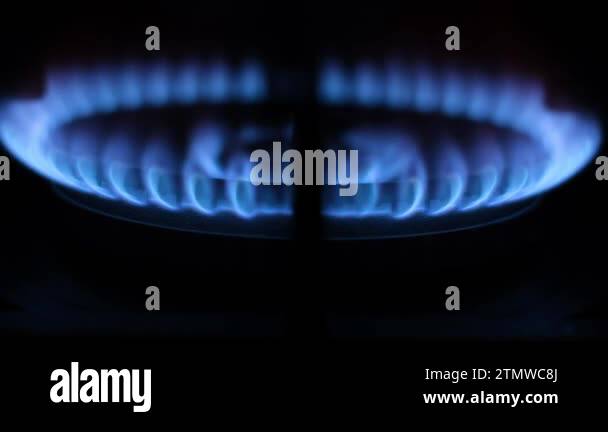 A kitchen gas stove with a blue flame. Zoomed video of blue flame of ...