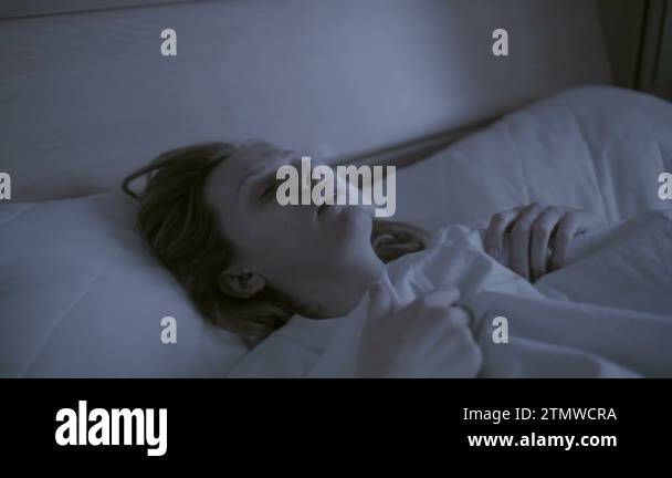 Restless dreams of sleeping woman interrupted by waking up for ...