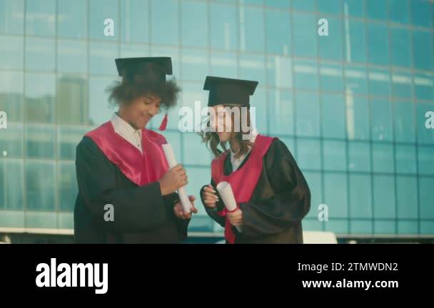 Happy Graduates in the Mantle and Caps Talking on Background of ...