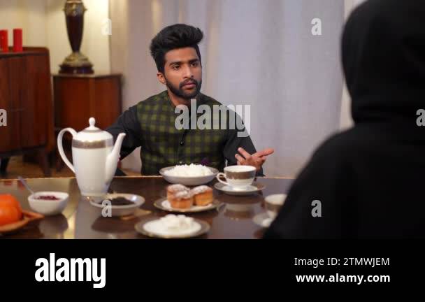 Irritated Middle Eastern young husband talking to unrecognizable wife ...