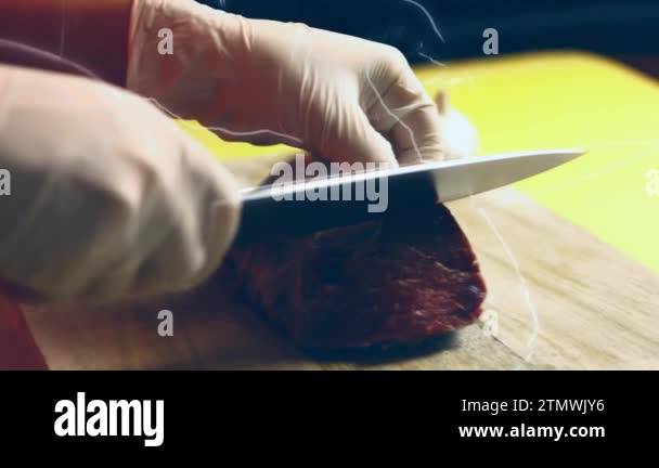 Chef cleans raw meat and cuts off connective tissue and surface ...