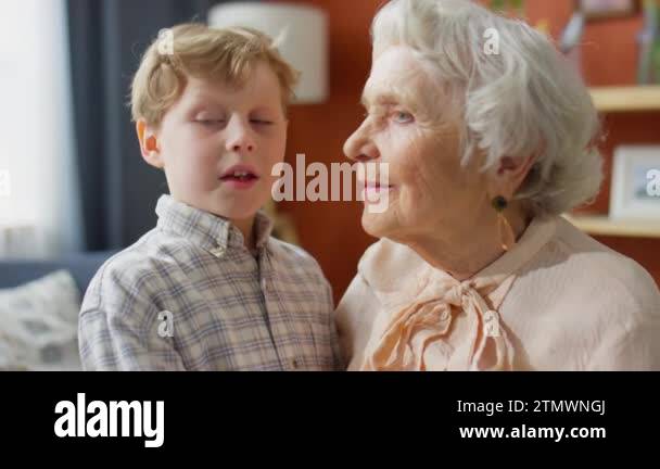 Cute little boy reciting poem to grandmother while having family ...