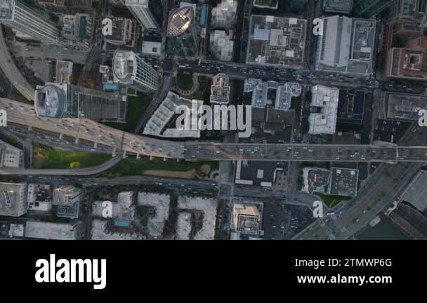 Top down footage of busy multilane roads leading between high rise office towers in business hub ...