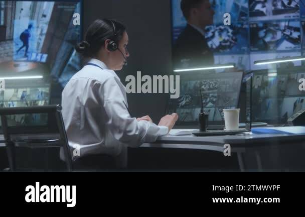 Female security officer works on computer in police monitoring center ...