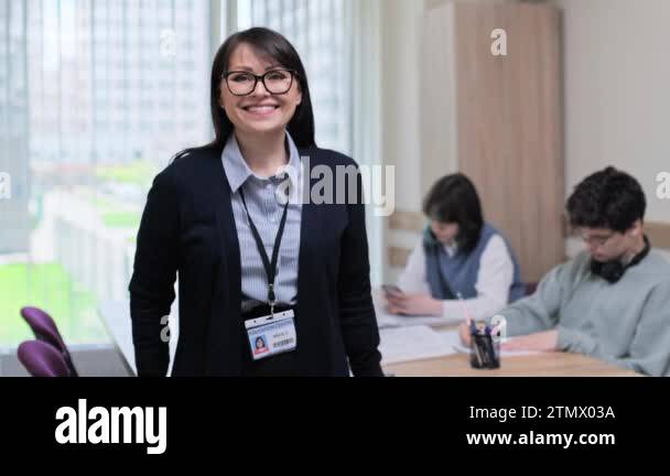 Portrait of confident middle aged female teacher schoolmaster tutor educator looking at camera ...