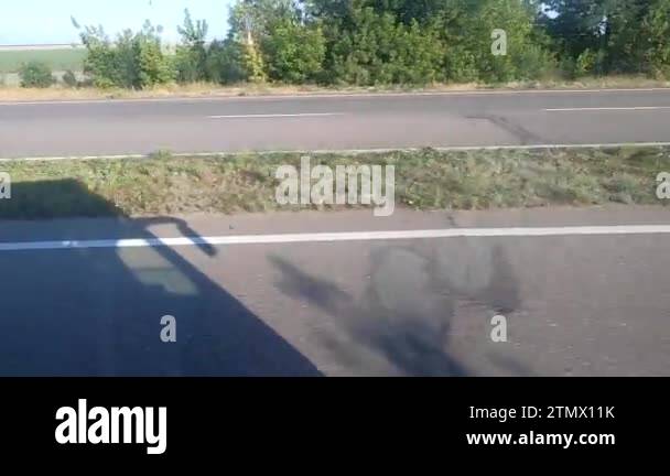 Shadow of the drivers cabin of a bus driving on an asphalt road. View ...
