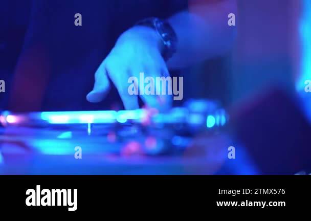 DJ mixes tracks on DJ console lit color music in nightclub party. Dj ...