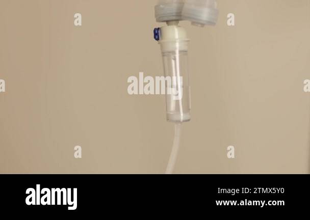 A ward in a hospital, a close-up of drops of saline in a drip, the ...