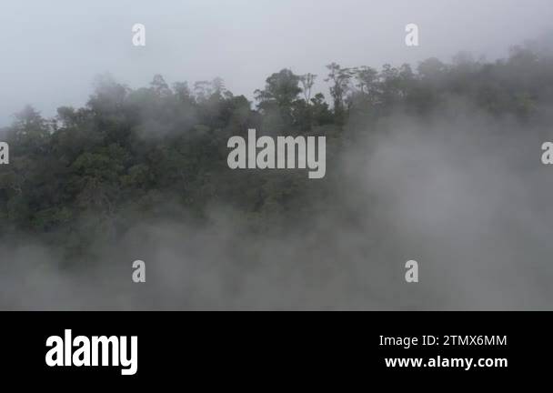 filming from a Drone, flying in the rain over mountains covered with ...