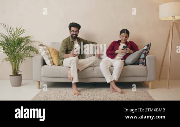 Full length portrait of busy married indian couple using smartphones ...