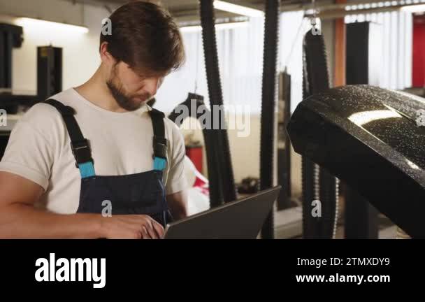 Vehicle wiring inspection. Engineer with laptop makes computer ...