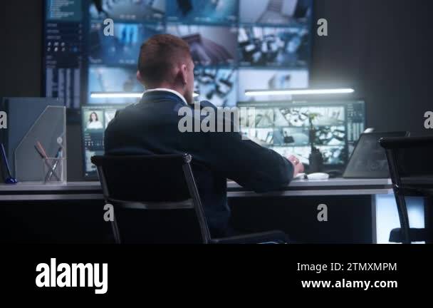 Male officer controls security cameras with AI face scanning. Female ...