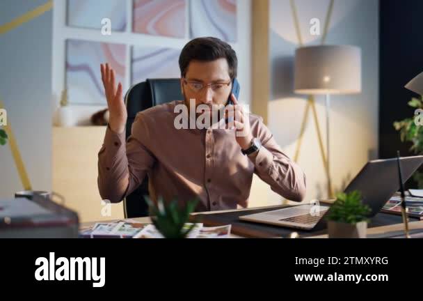 Exhausted worker talking smartphone worried profit loss sitting office ...