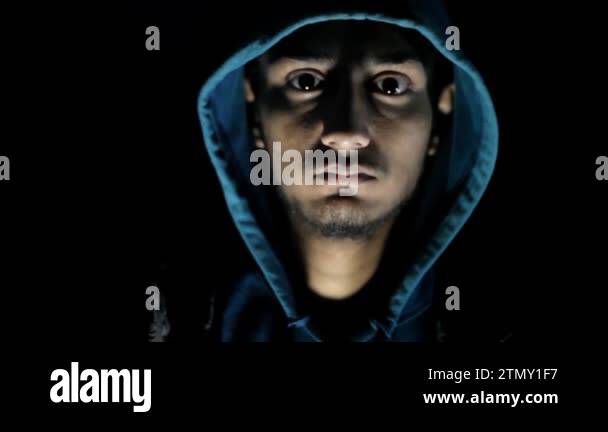 Horror film-like footage of a scared frightened boy looking sideways ...