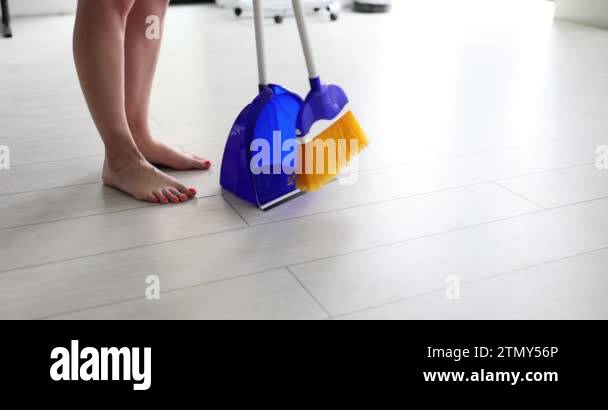 Household routine and closeup of woman with bare feet sweeping floor of ...