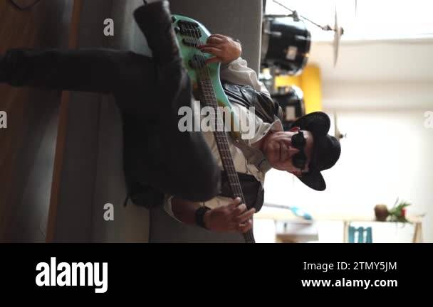 a mature rocker man is rehearsing at home with the guitar the bass ...