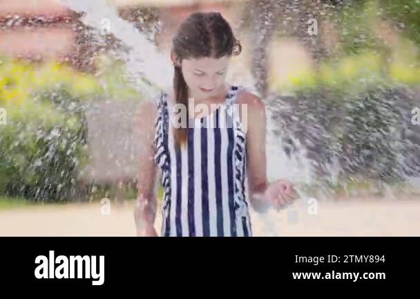 A video of a girl being splashed by water on her back at a waterpark ...