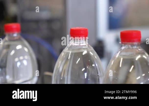 Production of drinking mineral water in plastic bottles. Close-up of ...