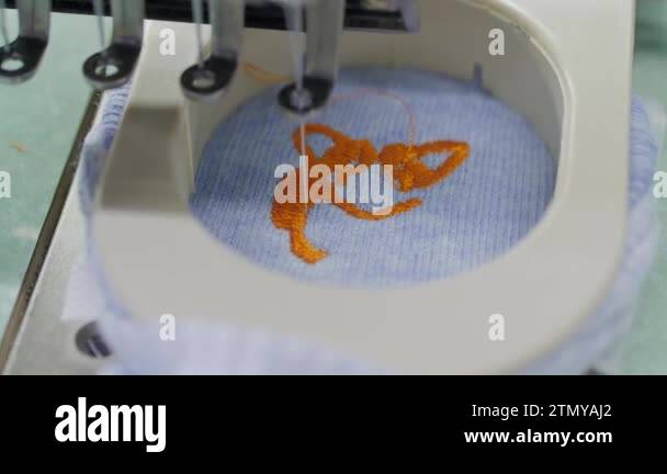 Embroidering a pattern on a sock. Automatic sock stitching at garment ...