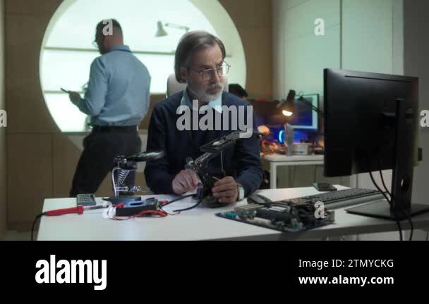 Hardworking Caucasian professor creating mechanical hand of robot at ...