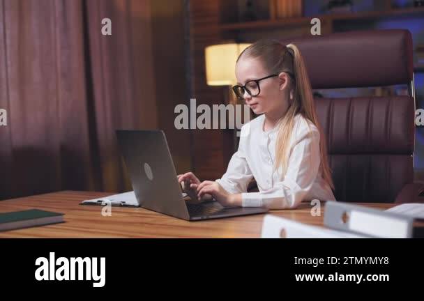 Formally dressed little office employee working in computer program and ...