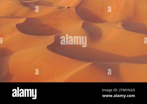 The drone flies to the quadra in cycles standing on sand dunes in the ...