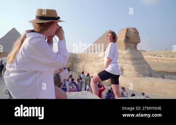 Giza, Egypt. December 2022. A girl takes a photo of her friend in front ...