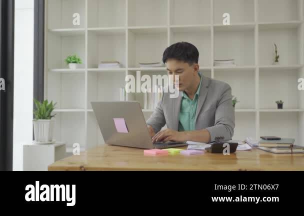 Asian business man Sitting working on laptop with office syndrome ...