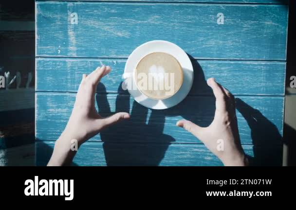 Beautiful girl hippy takes a mug of coffee from a vintage wooden blue ...