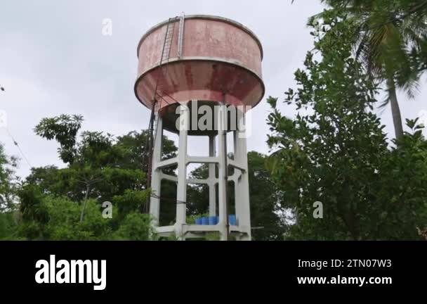 A low-angle view of a water tower in a small Indian village. old water ...