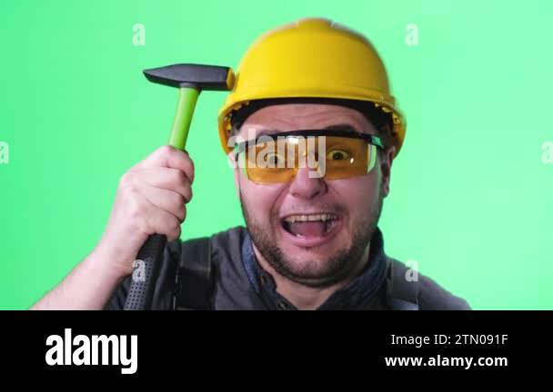 Construction worker strikes with a hammer using a hand-held metal tool ...