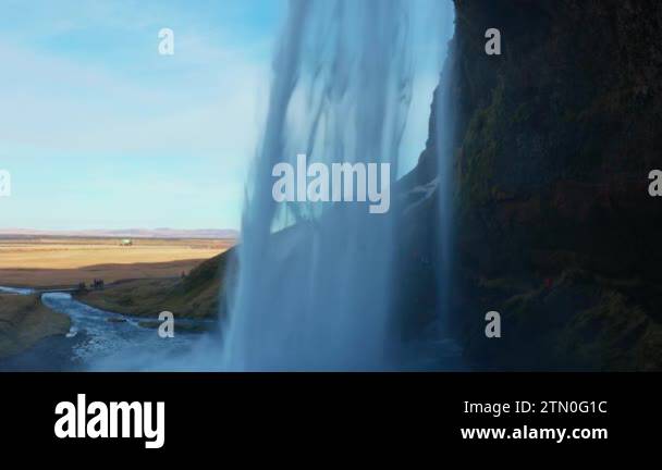 Arctic seljalandsfoss waterfall water flowing down of high cliff in ...