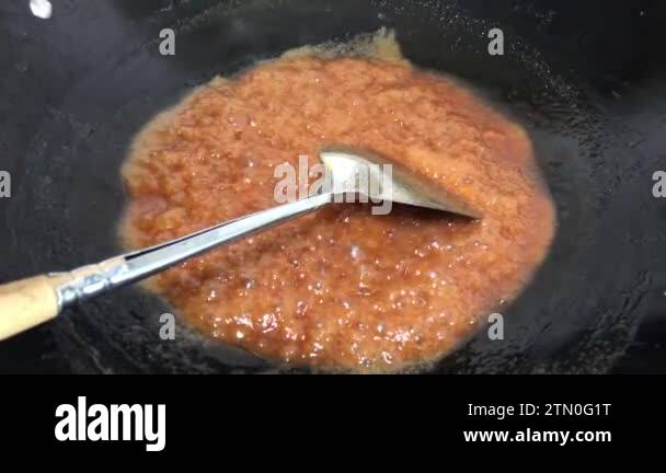 Melted sugar boils in a pan over medium heat stove, makes hot salted ...