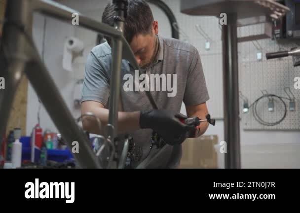 Bicycle mechanic holding syringe with brake fluid during brake bleeding ...