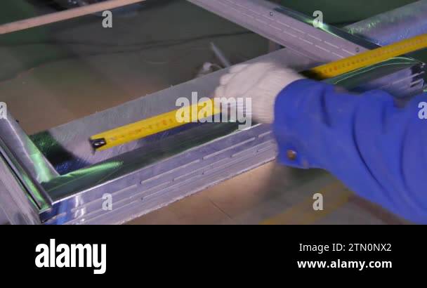 A man measuring a part to make sure of the width before cutting it. a ...