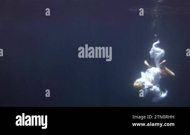 Young girl model free diver underwater white angel costume poses in Red ...