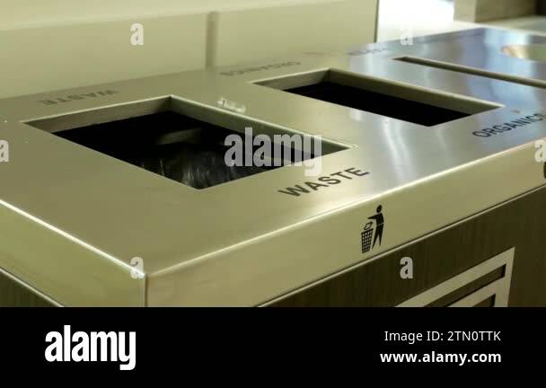 Woman throwing trash to the garbage can inside shopping mall Stock ...