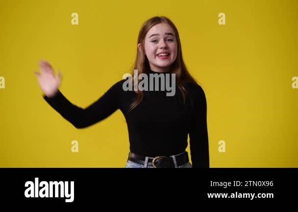 4k video of girl with cunning facial expression on yellow background ...
