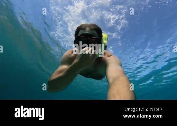 UNDERWATER: Sporty guy dives into crystal clear turquoise water of ...