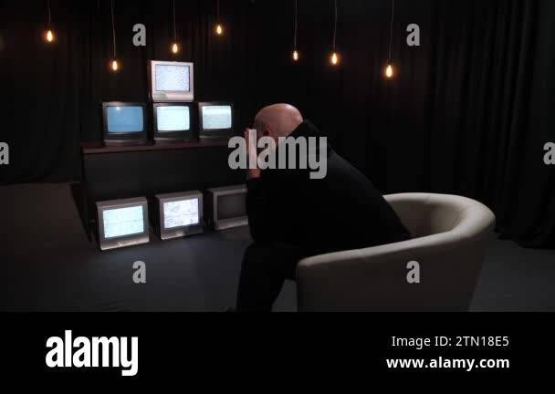 An agitated man looks at the static noise on the screens of many ...