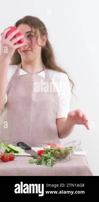 young woman jokes she shows how a red bell pepper strikes her on the ...